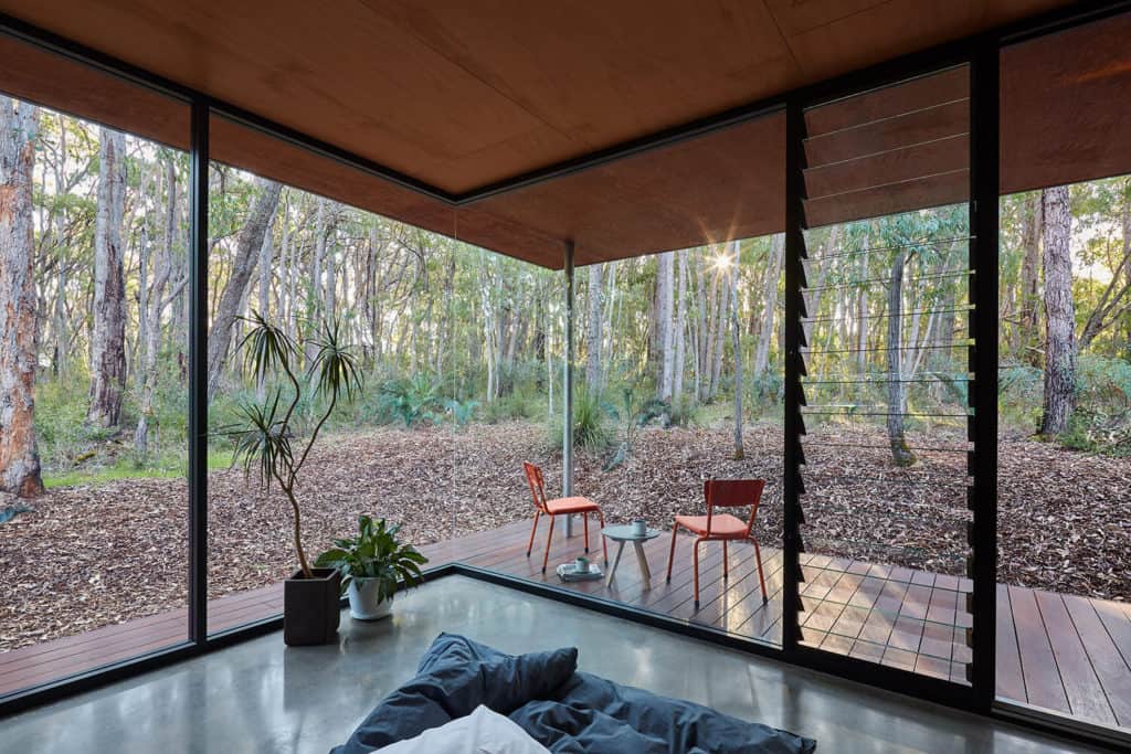 Compact pavilion house surrounded by dense Australian bushland