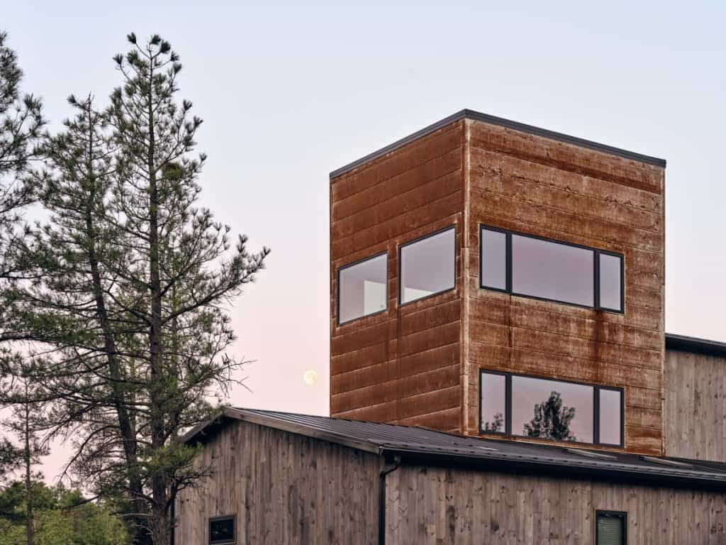 A rusted steel tower defines this Arizona house in a Ponderosa pine forest