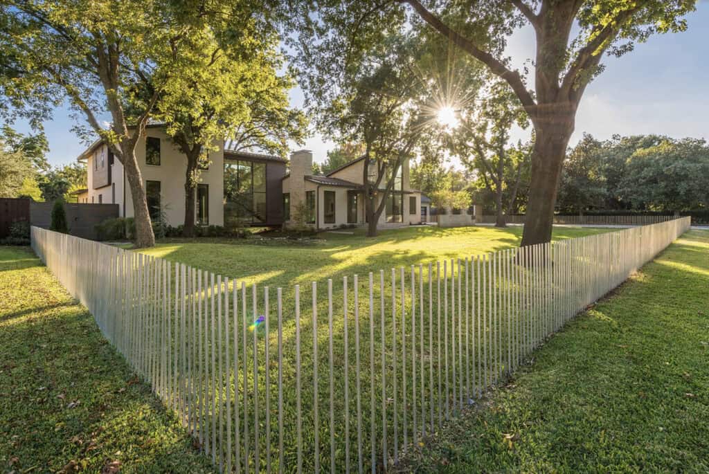 This striking Dallas home features a glass bridge over a serene landscape