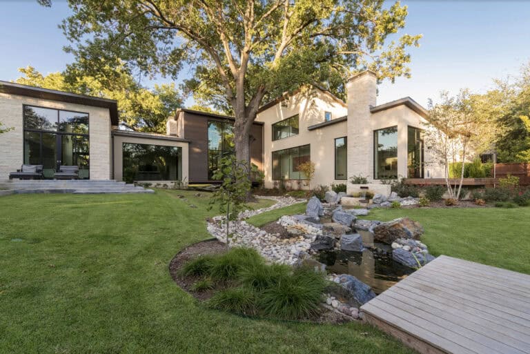 This striking Dallas home features a glass bridge over a serene landscape