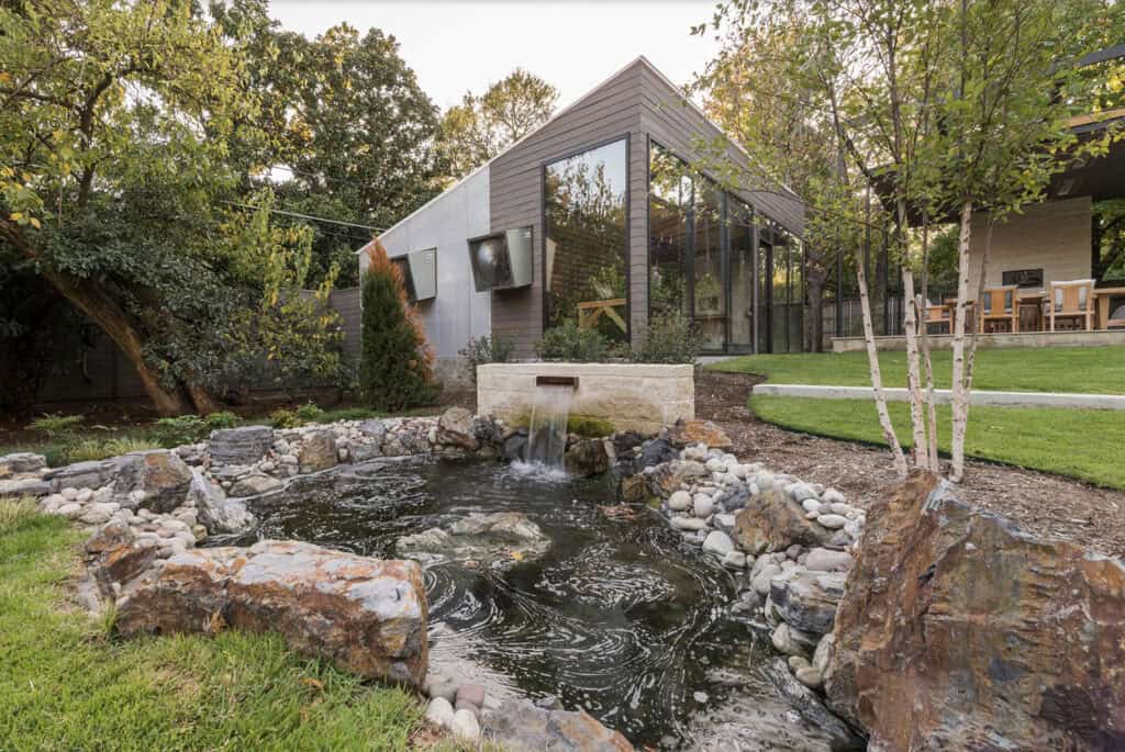 This striking Dallas home features a glass bridge over a serene landscape